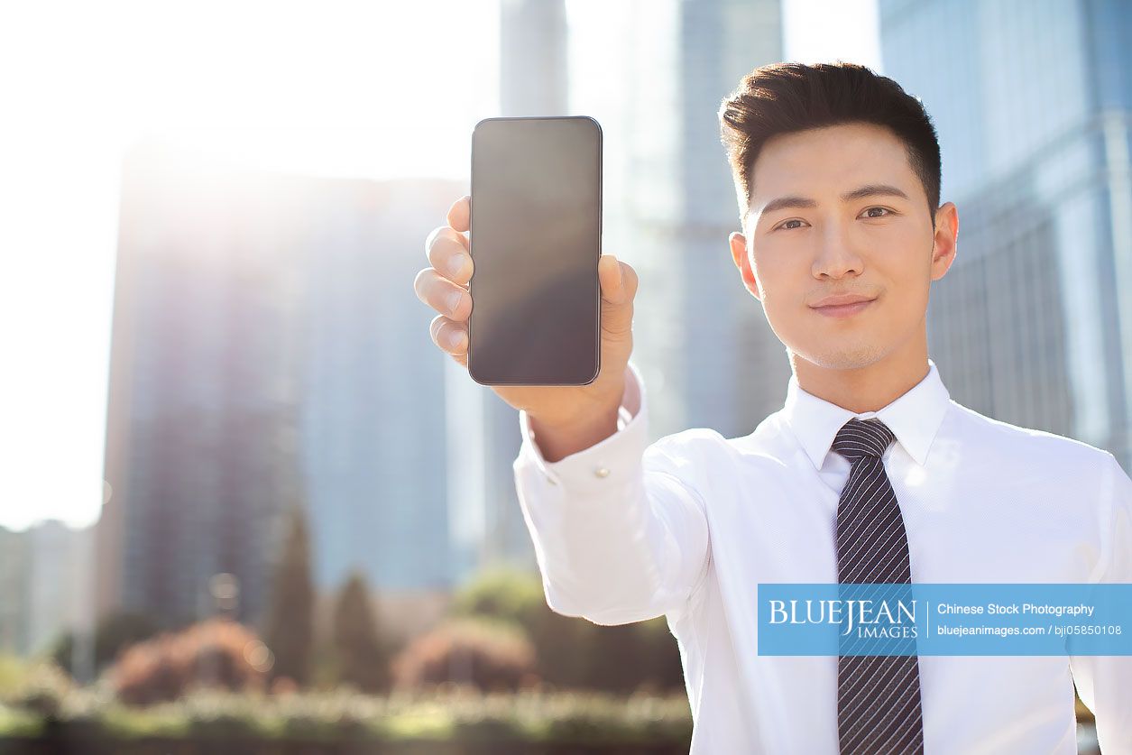 Young Chinese businessman showing the smart phone-High-res stock photo ...