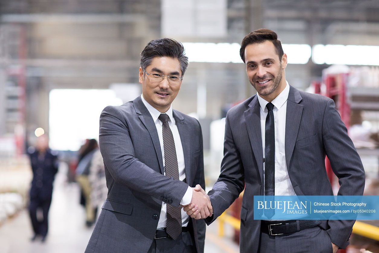 Business people shaking hands in the factory-High-res stock photo for download