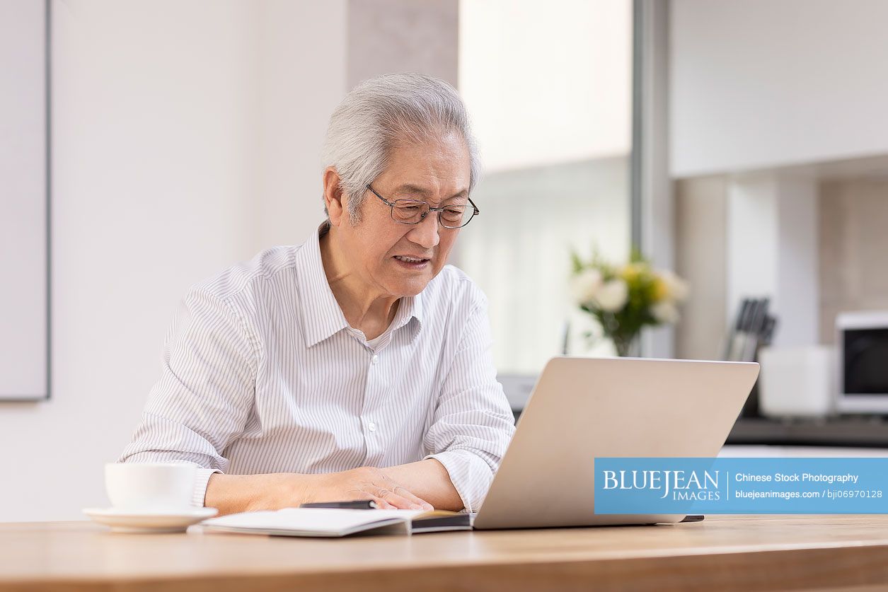 Senior Chinese man using laptop at home-High-res stock photo for download