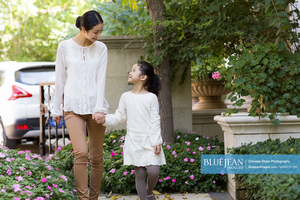 Chinese mother and daughter holding hands walking together-High-res ...