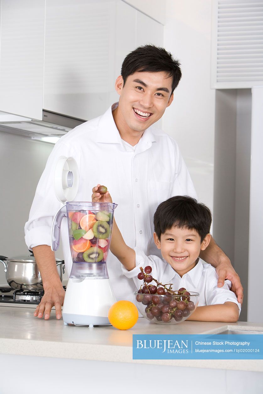 Chinese father and son making fresh fruit juice in kitchen-High-res ...