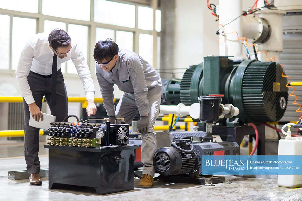 Businessman and engineer checking machine in the factory-High-res stock ...