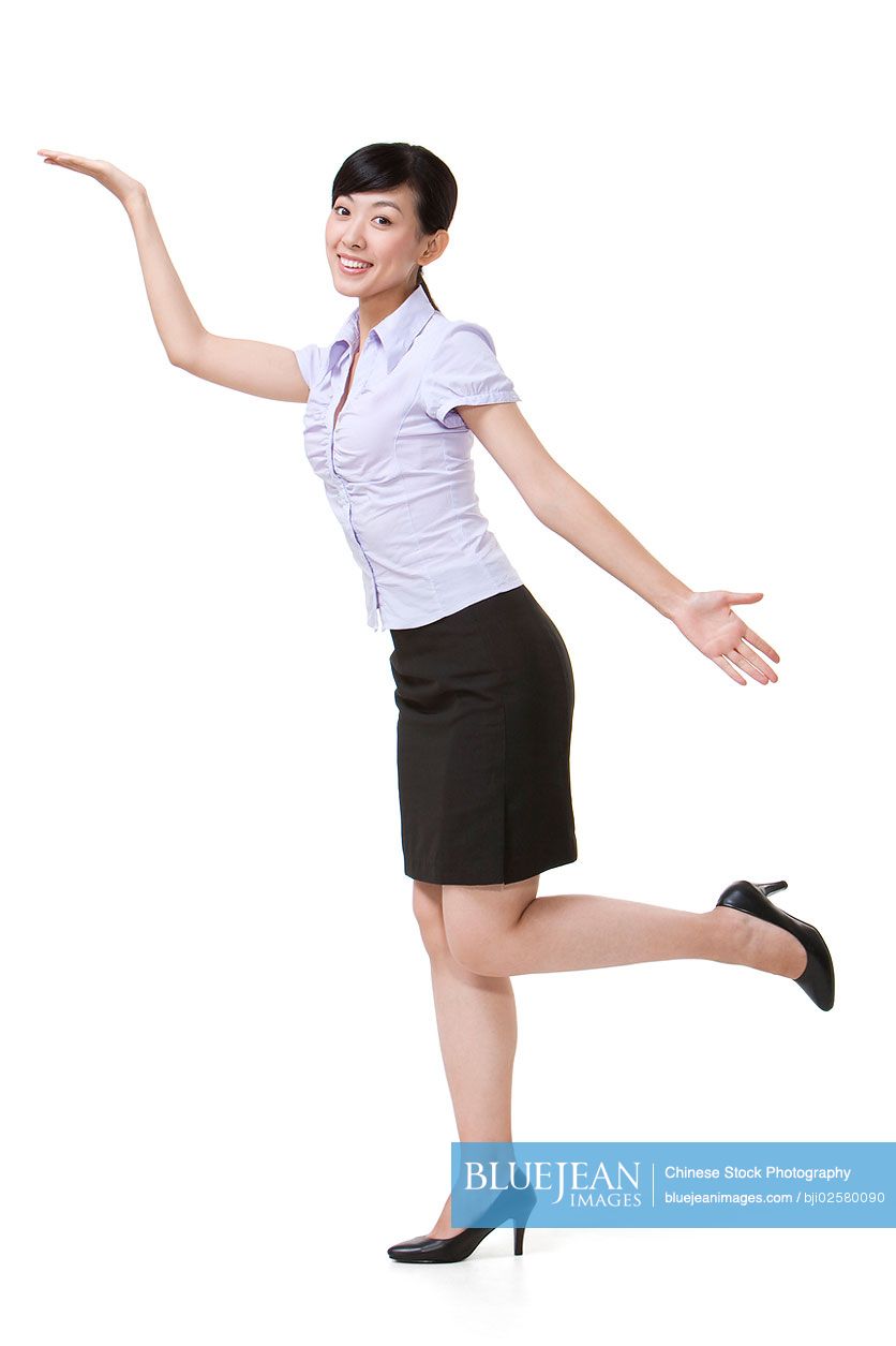 Confident Chinese businesswoman standing on one leg-High-res stock photo for download