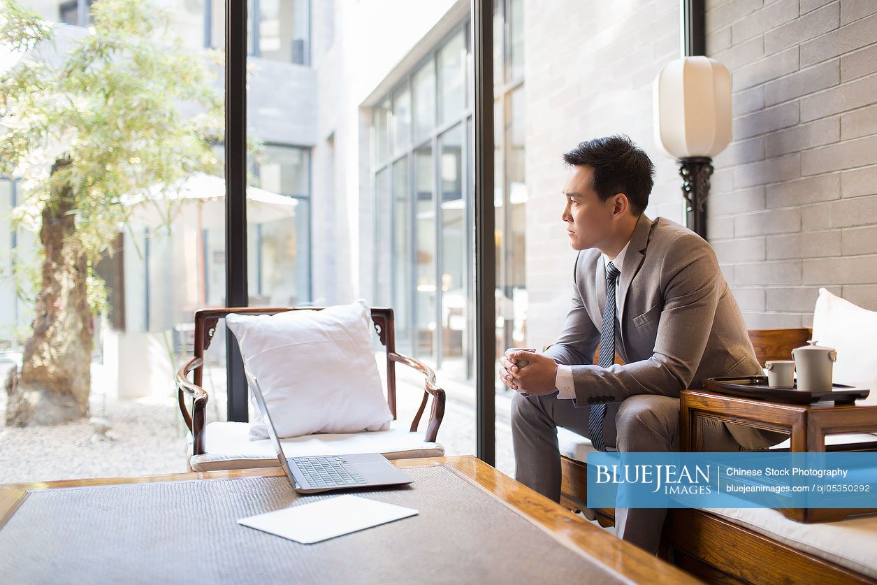 Confident Chinese businessman using laptop-High-res stock photo for download