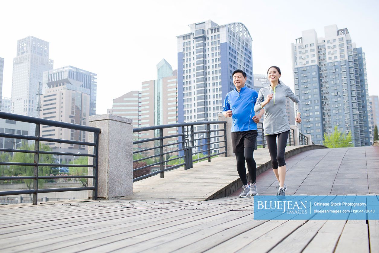 Happy mature Chinese couple running in park-High-res stock photo for download