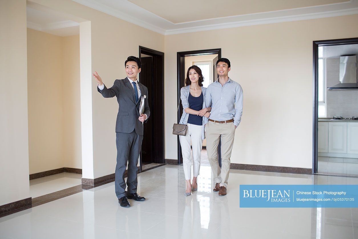 Chinese realtor showing new house to young couple-High-res stock photo ...