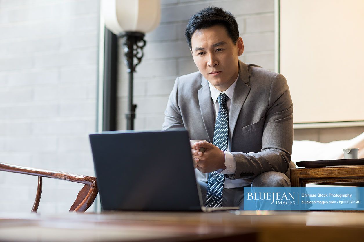 Confident Chinese businessman using laptop-High-res stock photo for ...