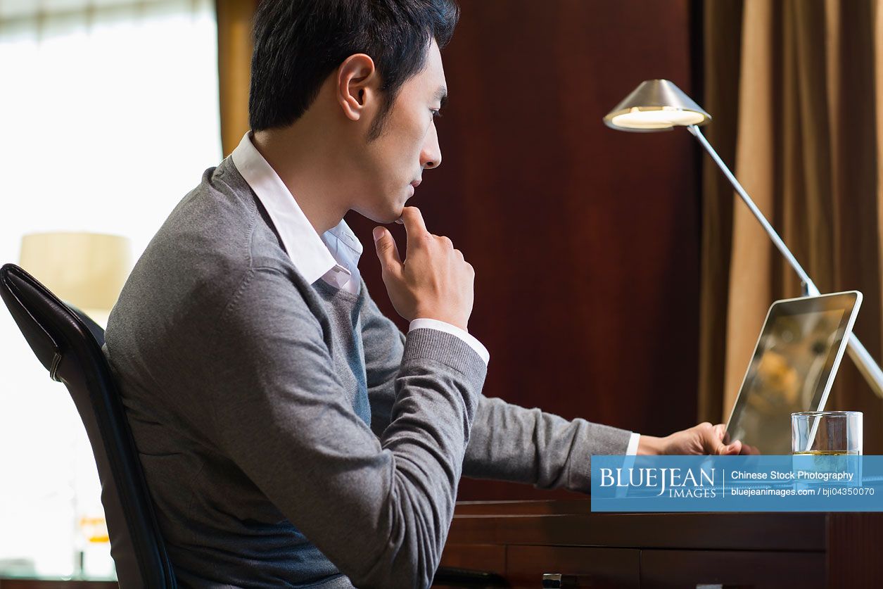 Young Chinese businessman using digital tablet in study-High-res stock ...