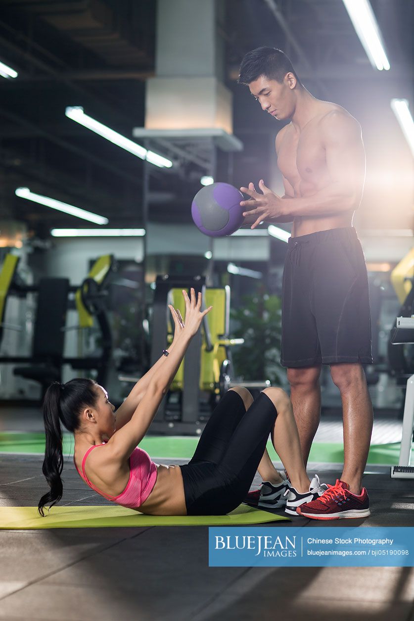 Young Chinese woman working with trainer at gym-High-res stock photo for download