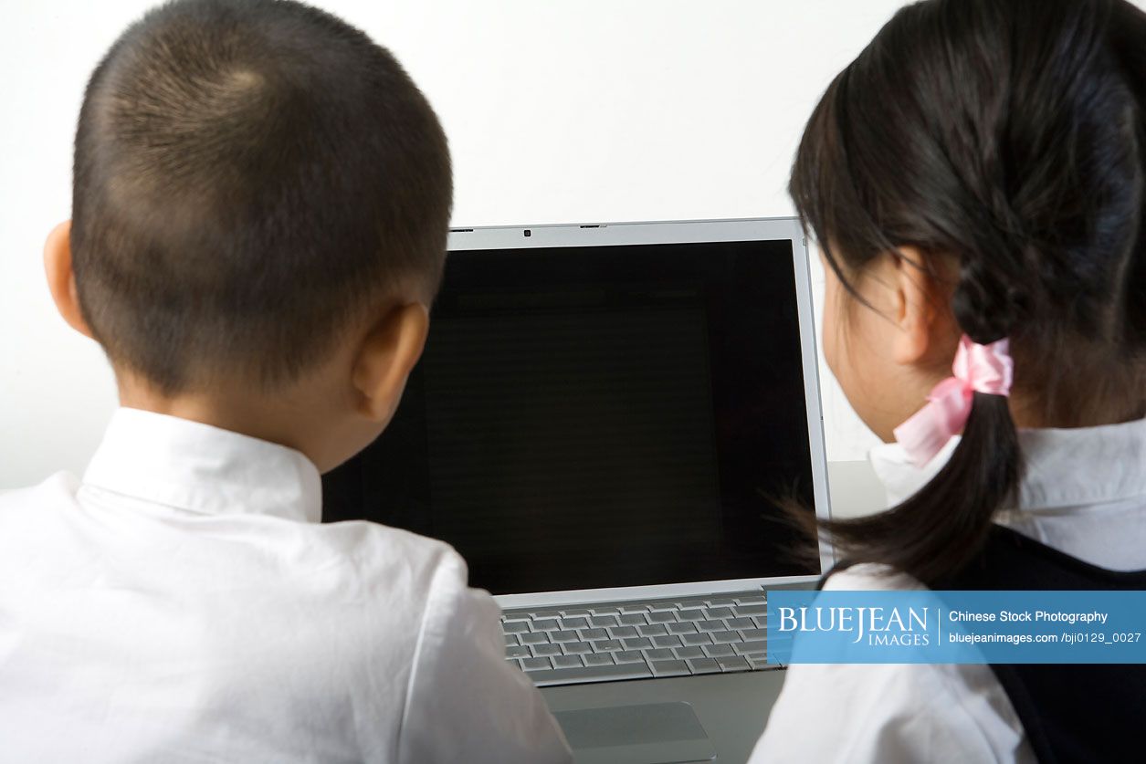 Chinese boy and girl use a laptop-High-res stock photo for download