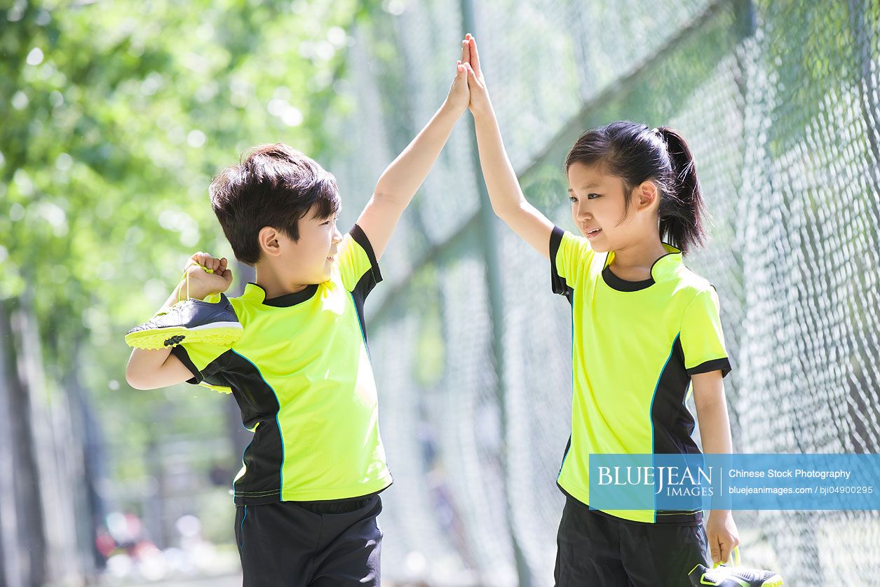 Happy Chinese children in sportswear high fiving-High-res stock photo ...