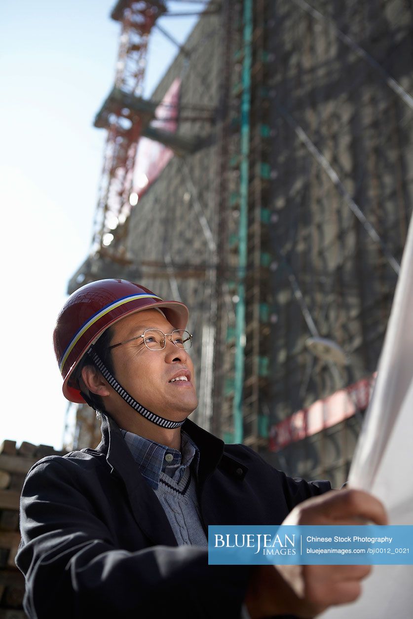 Chinese businessman in construction site wearing hard hat-High-res ...