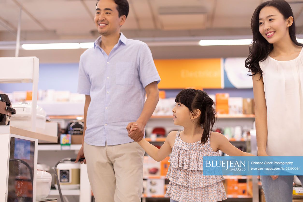 Happy young Chinese family shopping in supermarket-High-res stock photo ...