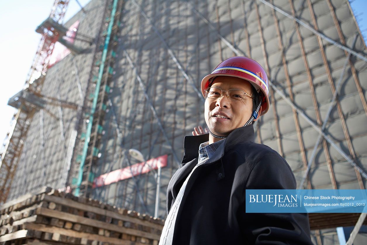 Chinese businessman in construction site wearing hard hat-High-res ...
