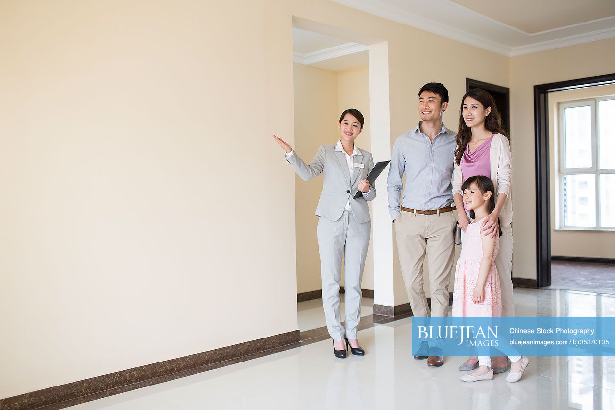 Chinese realtor showing new house to young family-High-res stock photo for download