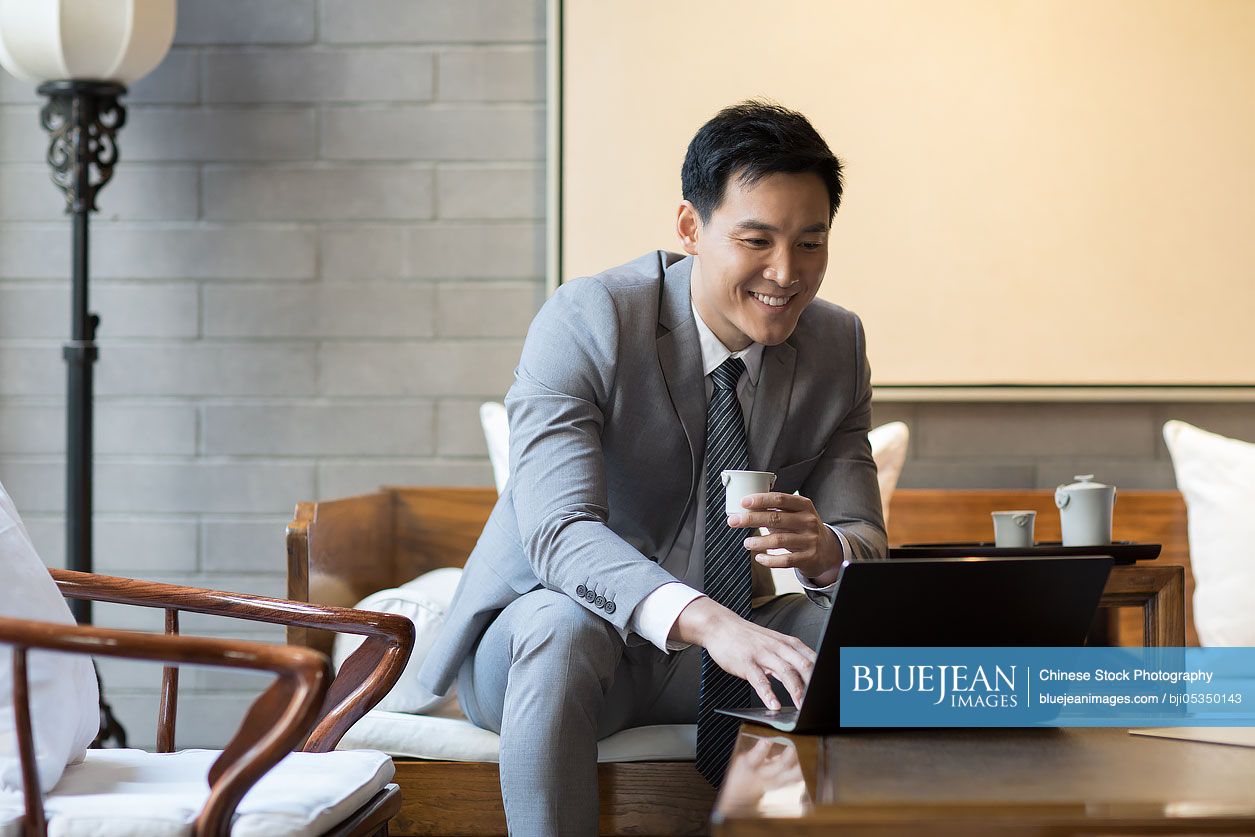 Cheerful Chinese businessman using laptop-High-res stock photo for download