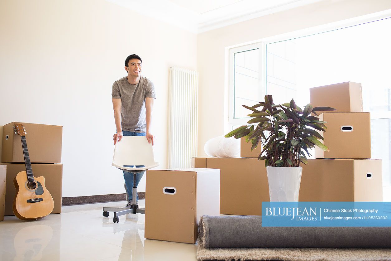 Happy young Chinese man moving to a new house-High-res stock photo for ...