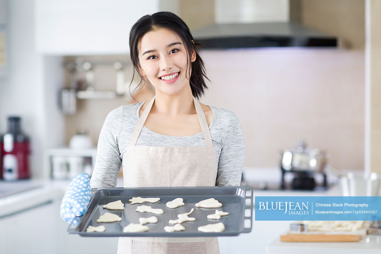 Young Chinese woman making cookies in kitchen-High-res stock photo for ...