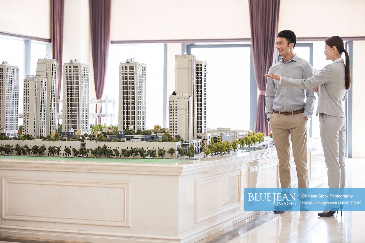 Chinese realtor showing architectural model to young man-High-res stock ...