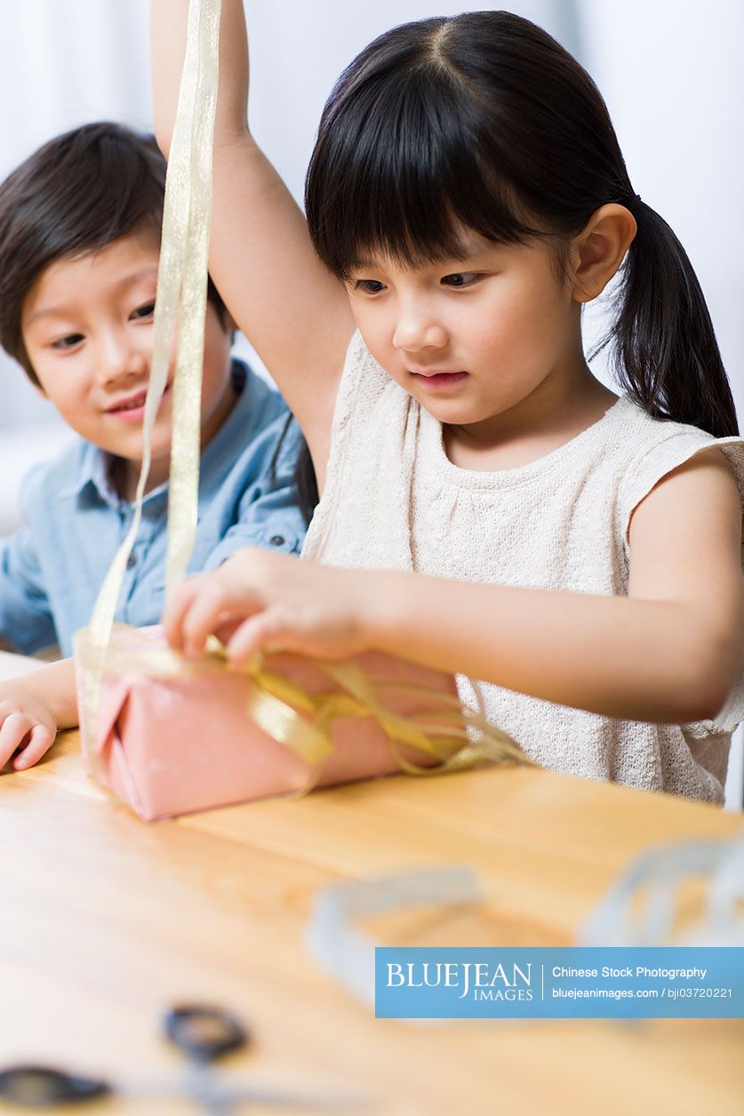 Little Chinese boy and girl wrapping gift box-High-res stock photo for download