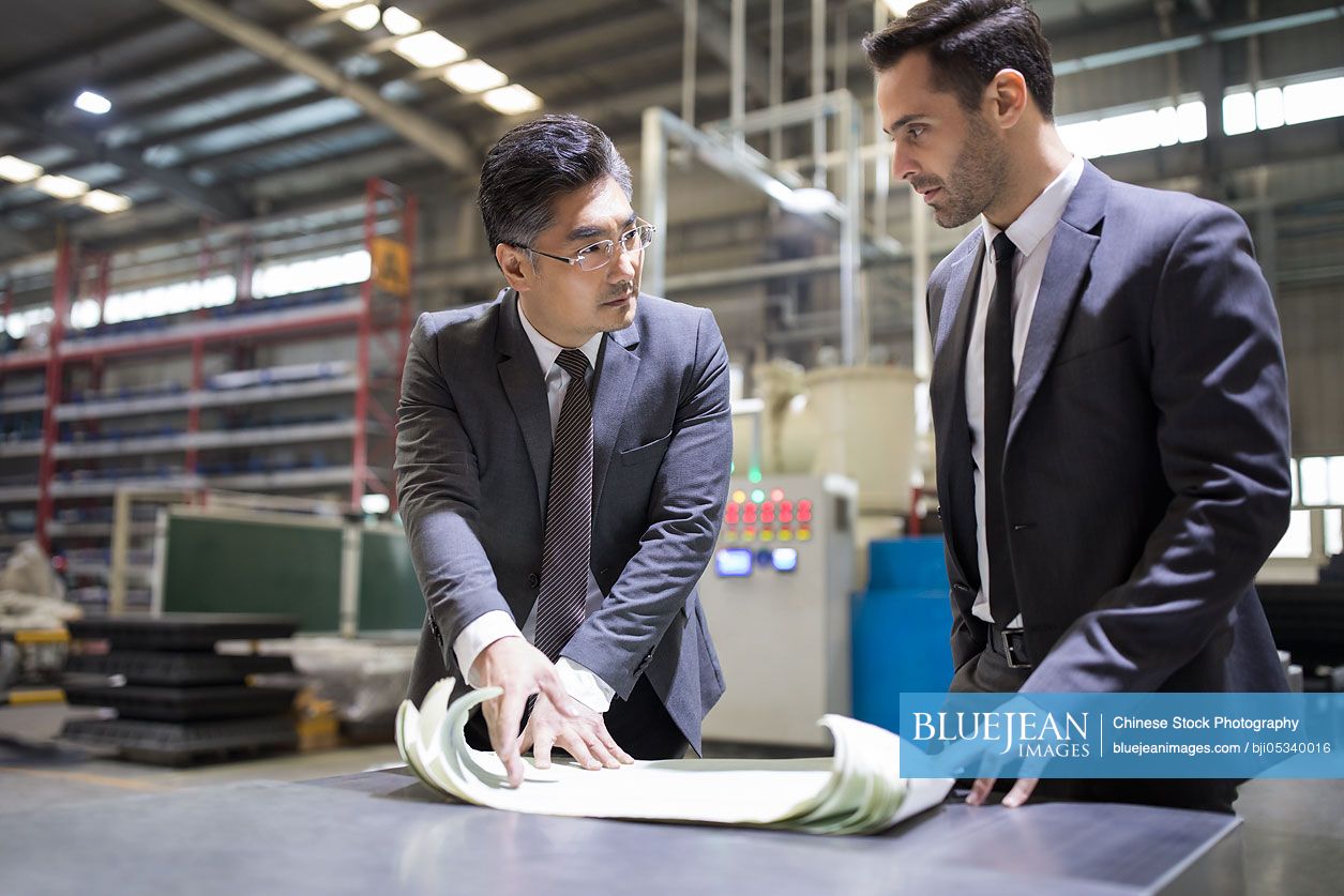 Businessman and engineer talking in the factory-High-res stock photo ...