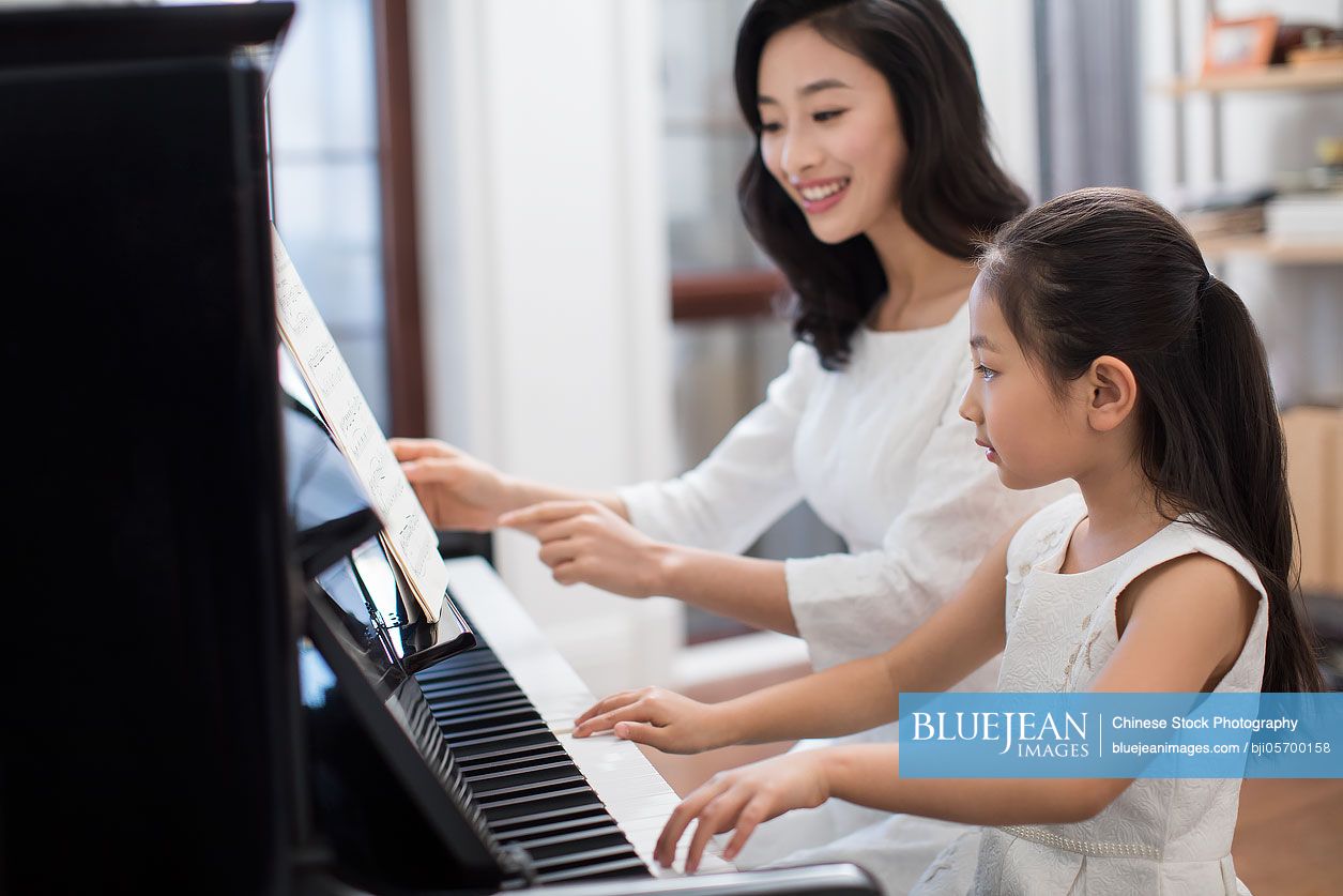 Chinese mother teaching daughter to play the piano-High-res stock photo ...