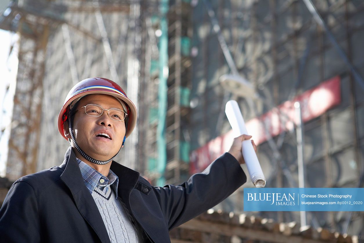 Chinese businessman in construction site wearing hard hat-High-res ...
