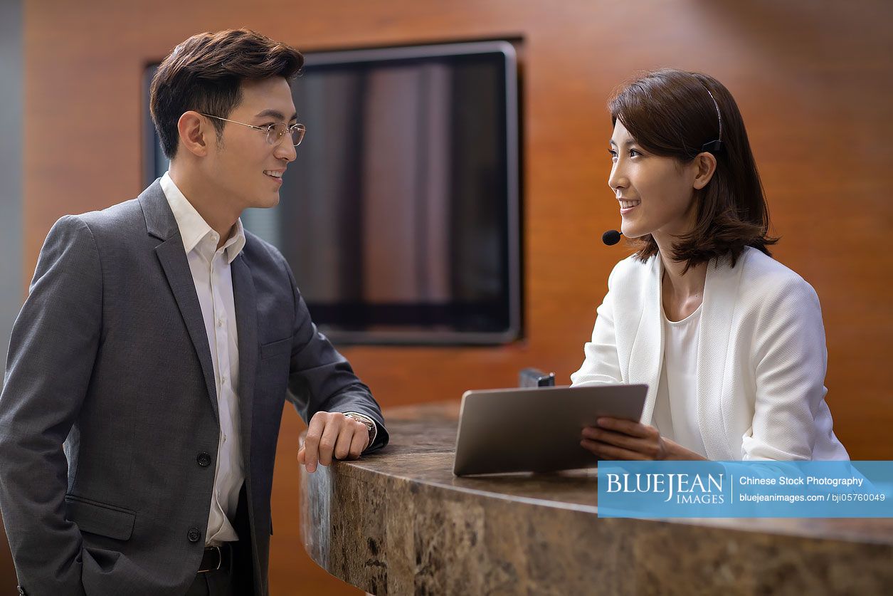 Chinese hotel receptionist talking with customer-High-res stock photo ...