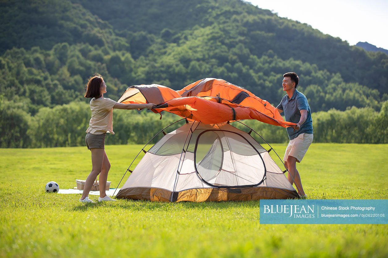 Happy young Chinese couple camping outdoors-High-res stock photo for download