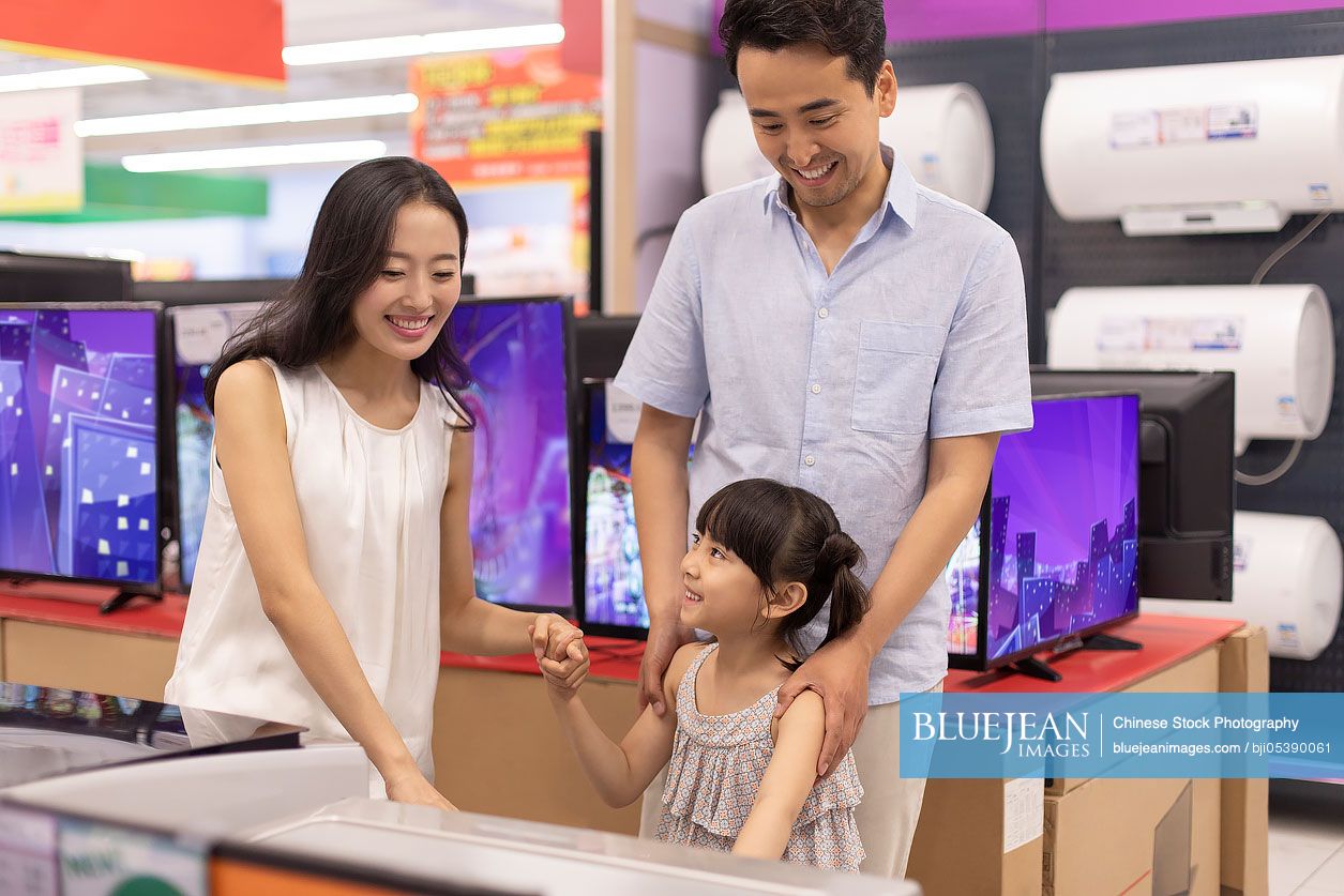 Happy young Chinese family shopping in supermarket-High-res stock photo ...