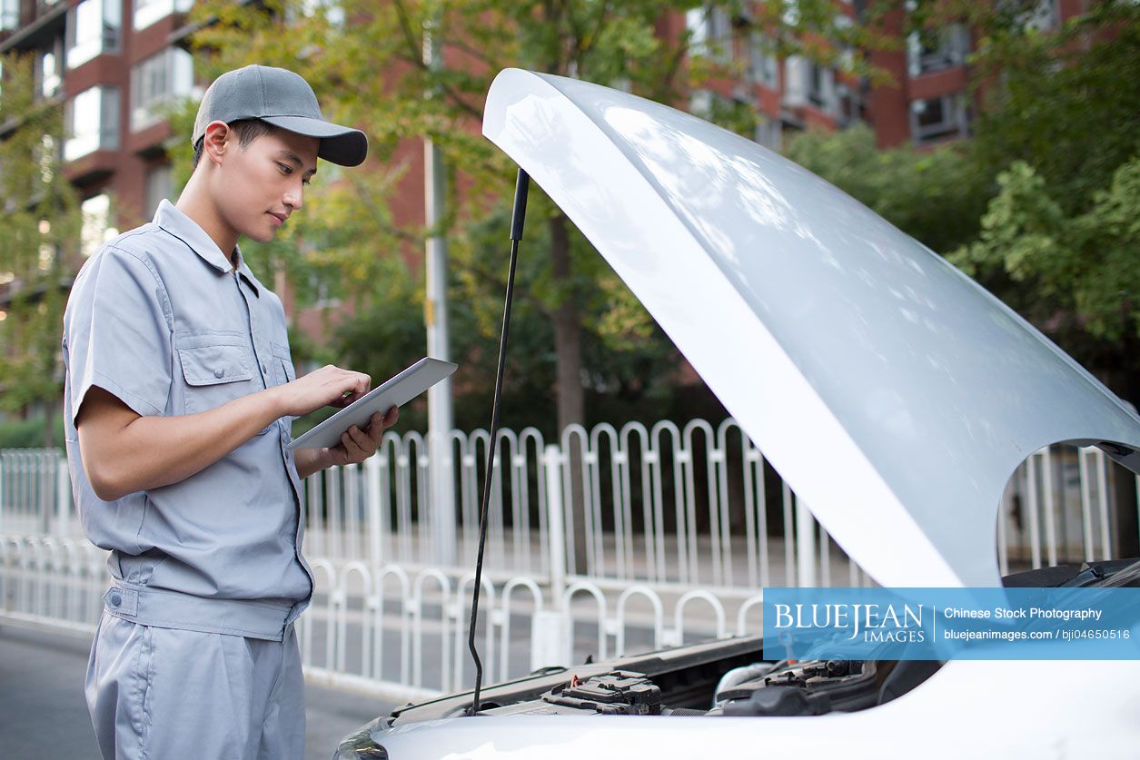 Chinese auto mechanic repairing car-High-res stock photo for download