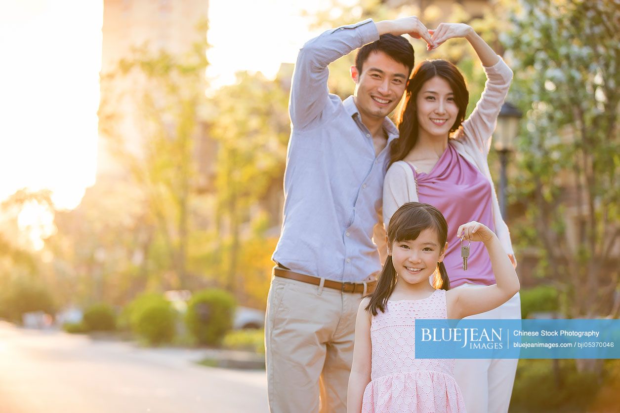 Happy young Chinese family holding keys to new house-High-res stock ...