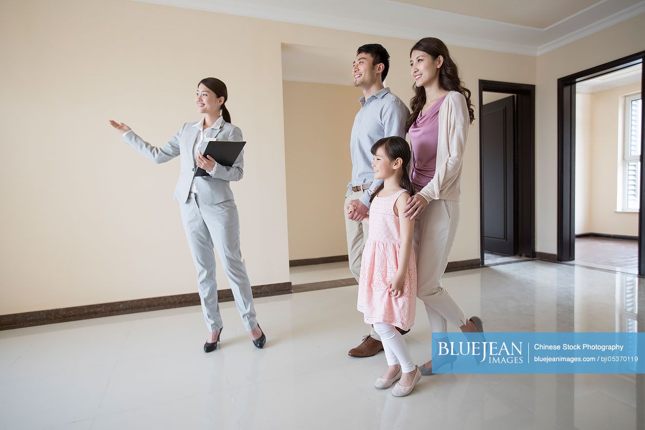 Chinese realtor showing new house to young family-High-res stock photo for download