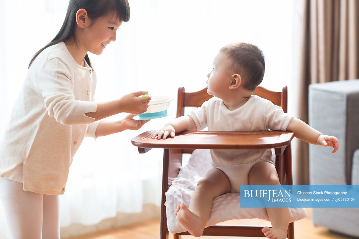 Little Chinese girl feeding baby-High-res stock photo for download