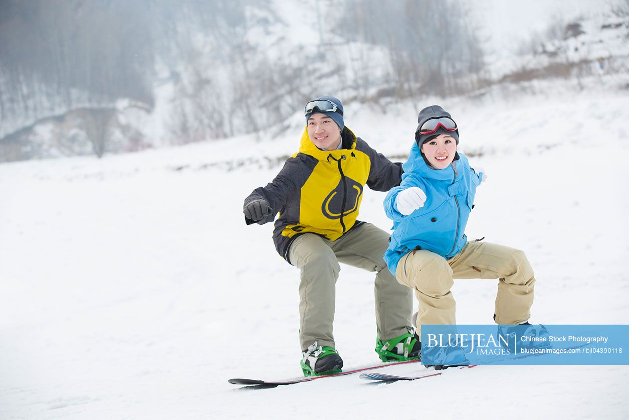 Young Chinese couple snowboarding in ski resort-High-res stock photo ...