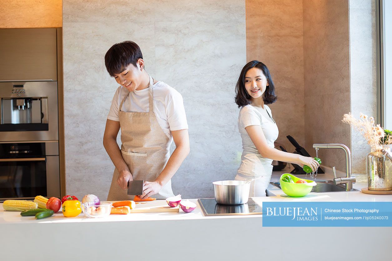 Happy young Chinese couple cooking in kitchen-High-res stock photo for ...