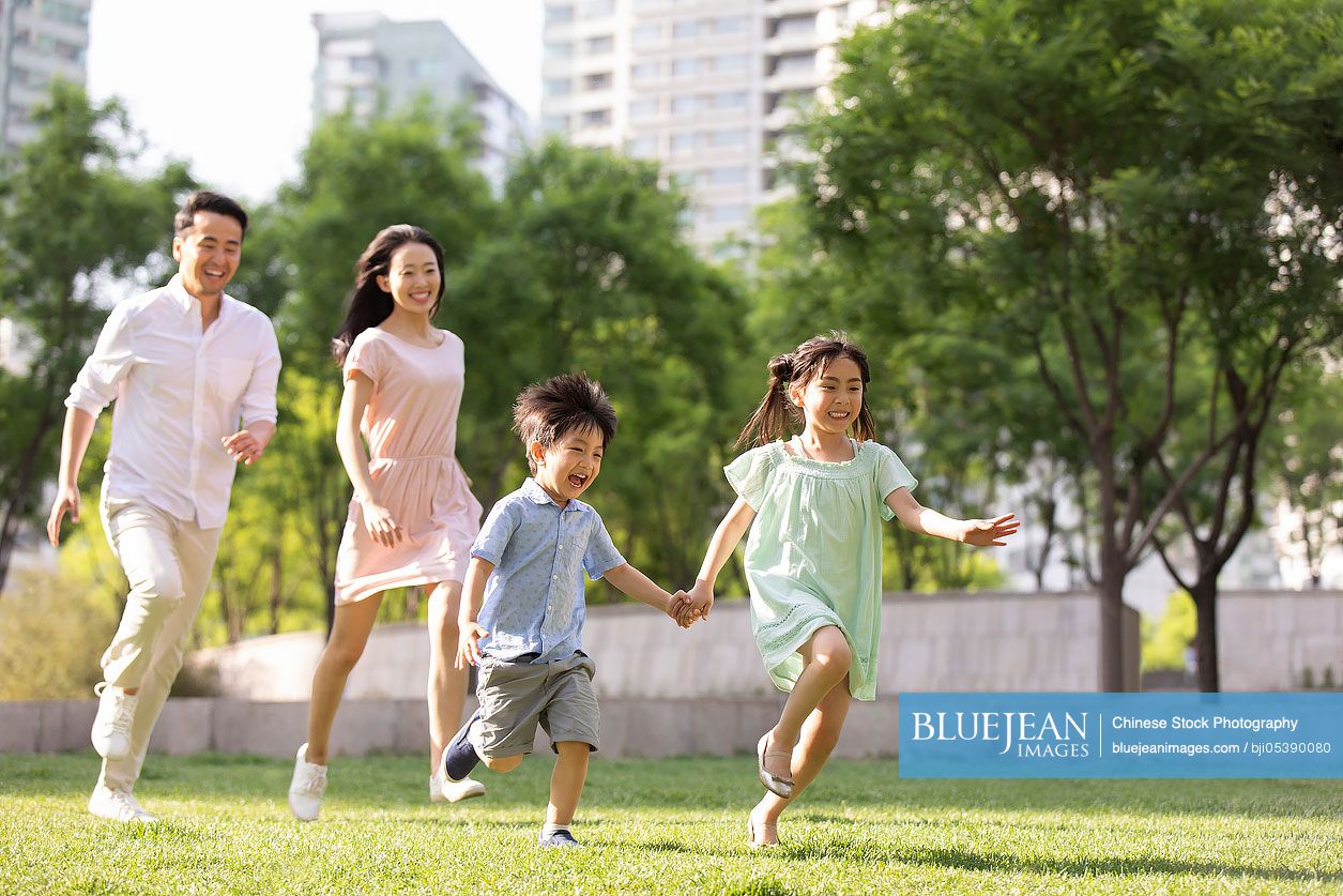 Happy young Chinese family playing in park-High-res stock photo for download