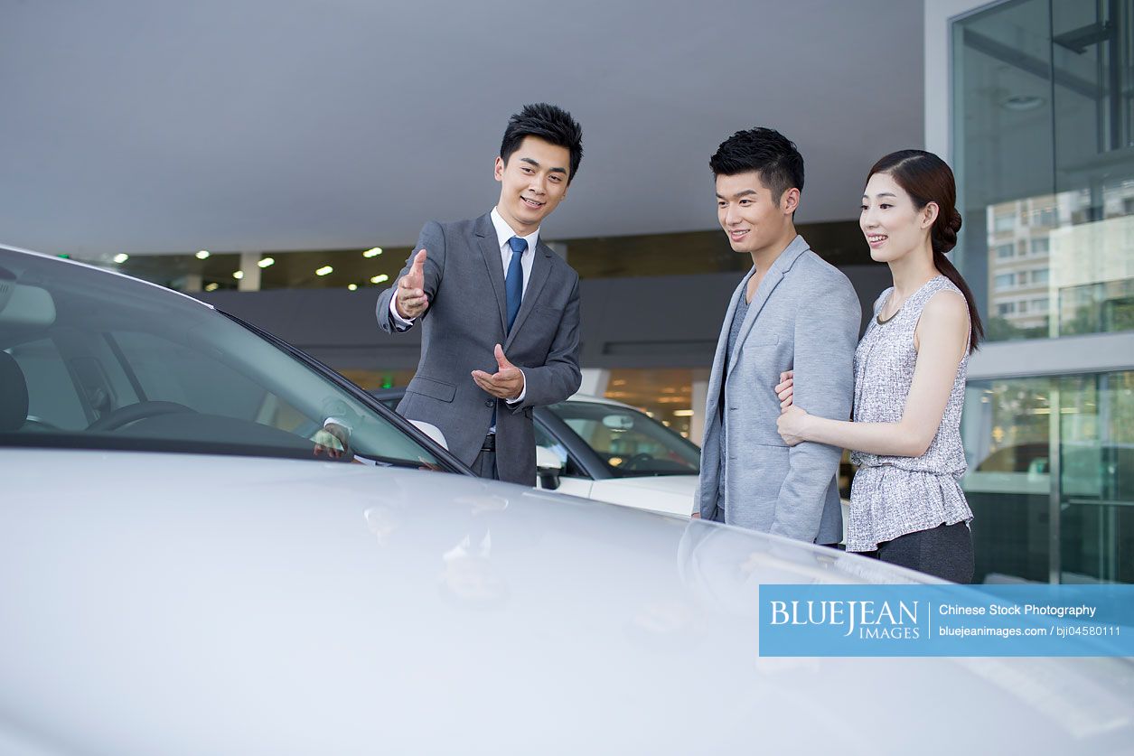 Young Chinese couple choosing car in showroom-High-res stock photo for ...