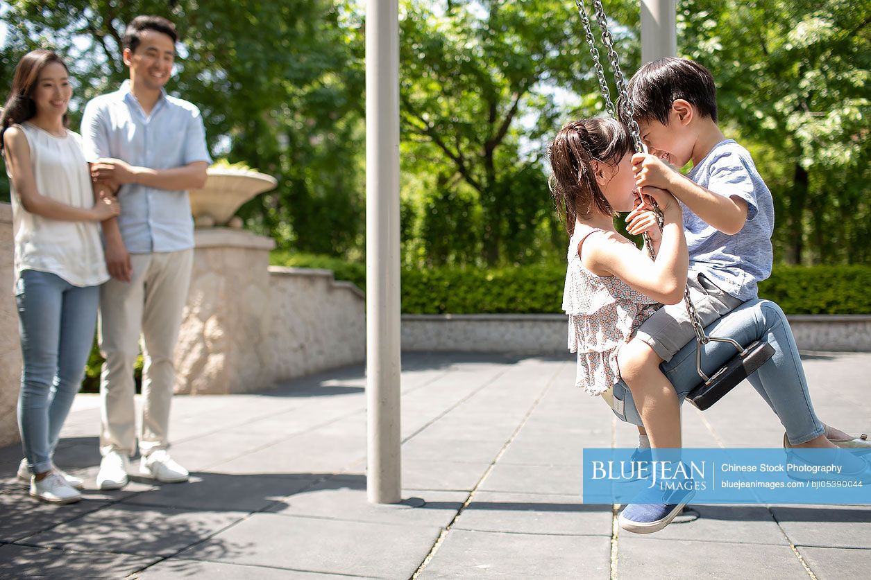 Happy young Chinese family playing on swing-High-res stock photo for ...