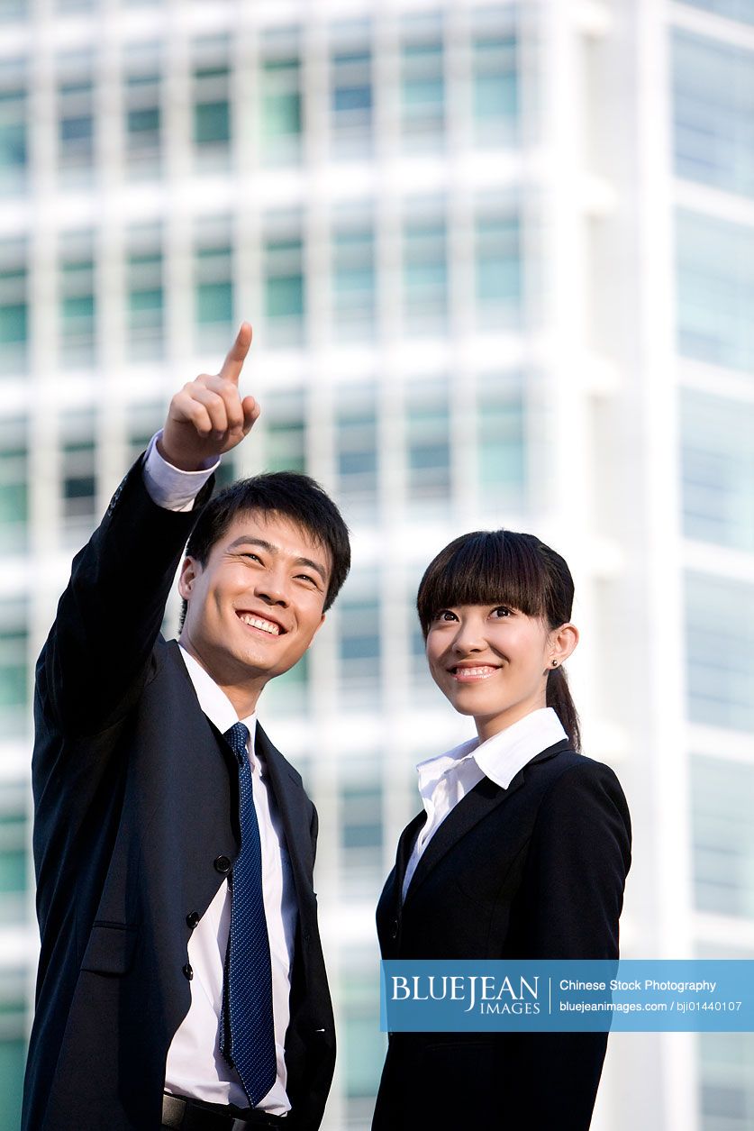 Two Chinese business professionals in front of skyscraper-High-res ...