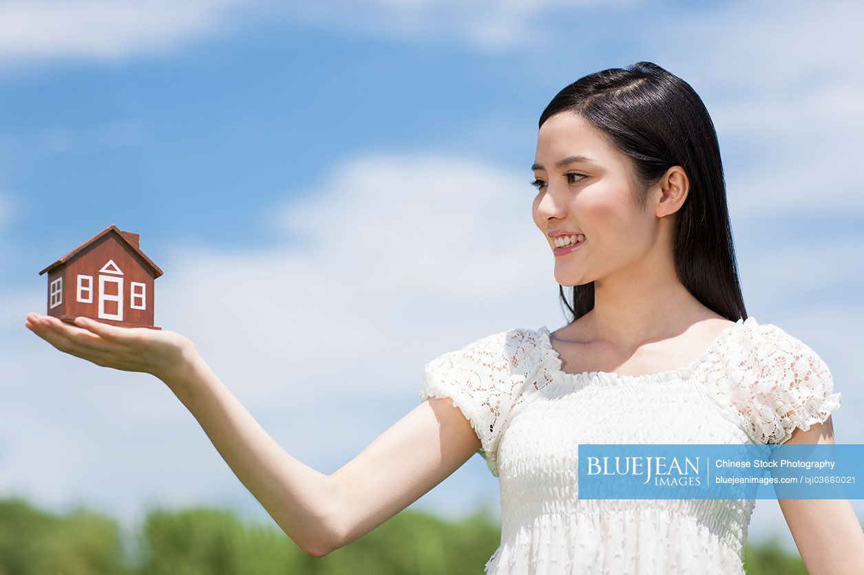 Young Chinese woman with toy house-High-res stock photo for download