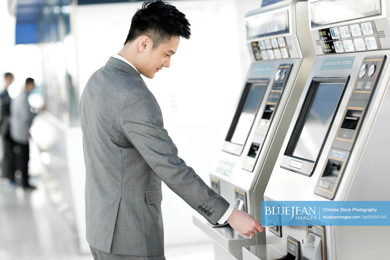 Young businessman using automatic ticket machine at subway station-High ...