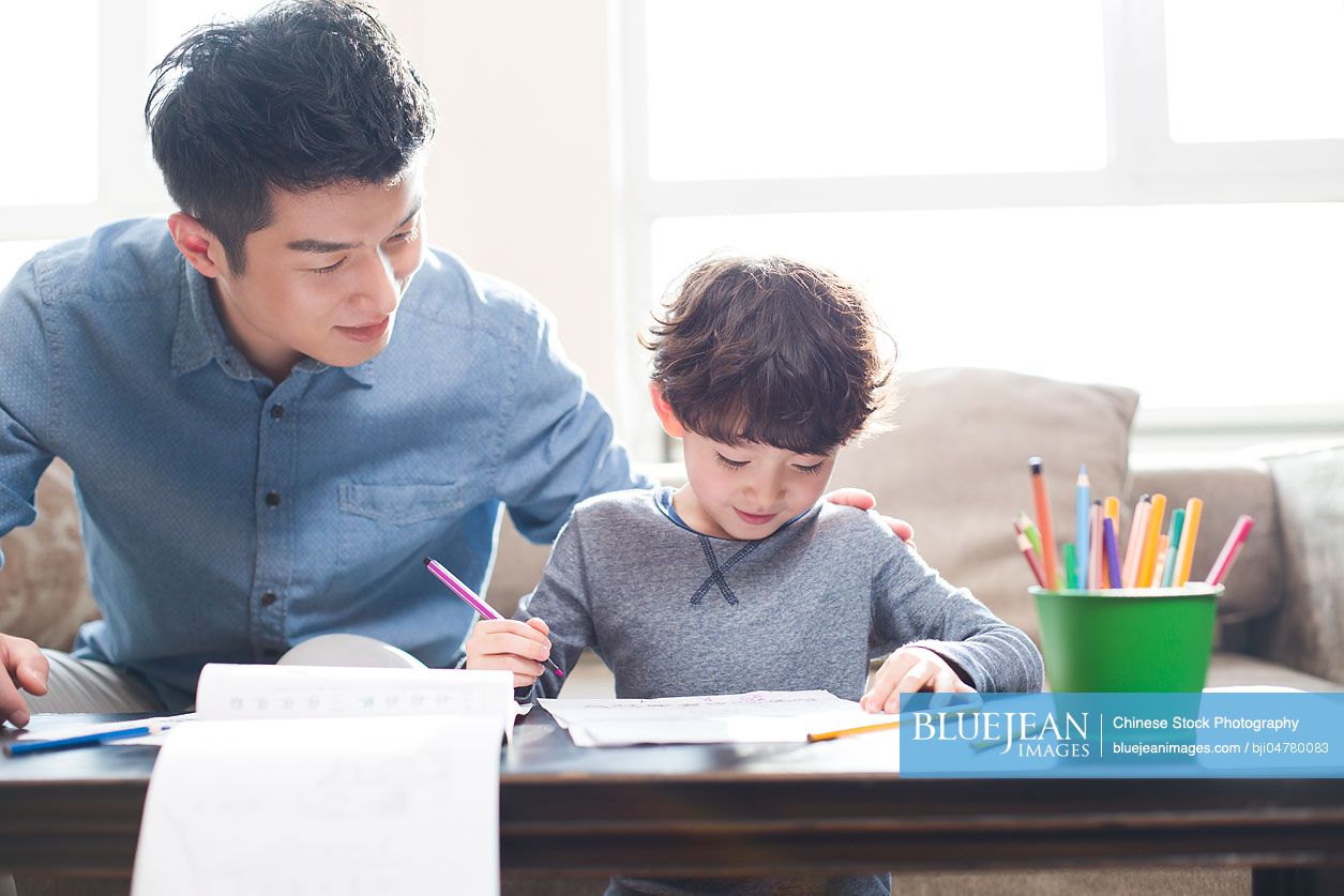 Young Chinese father helping son with homework-High-res stock photo for ...