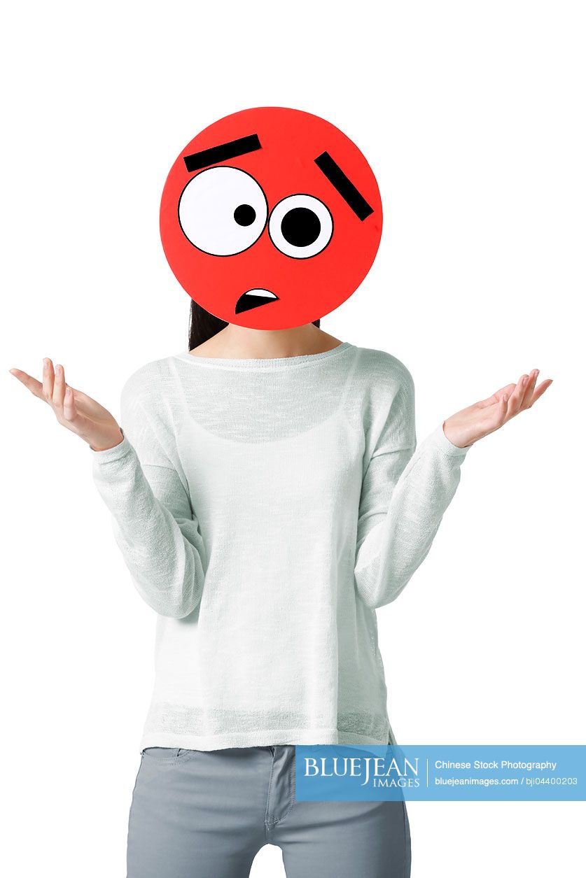 Young Chinese woman with a confused emoticon face in front of her face ...