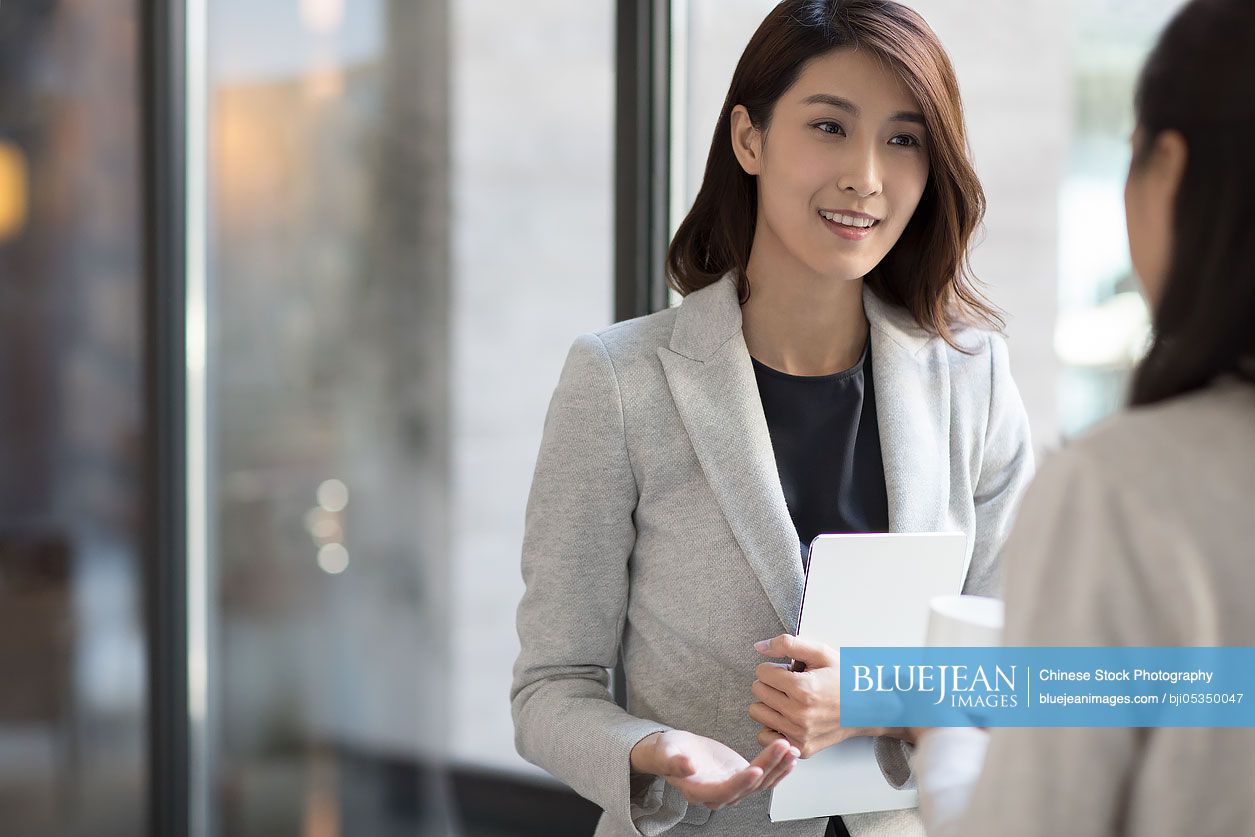 Confident Chinese businesswoman talking with a mature woman-High-res stock photo for download