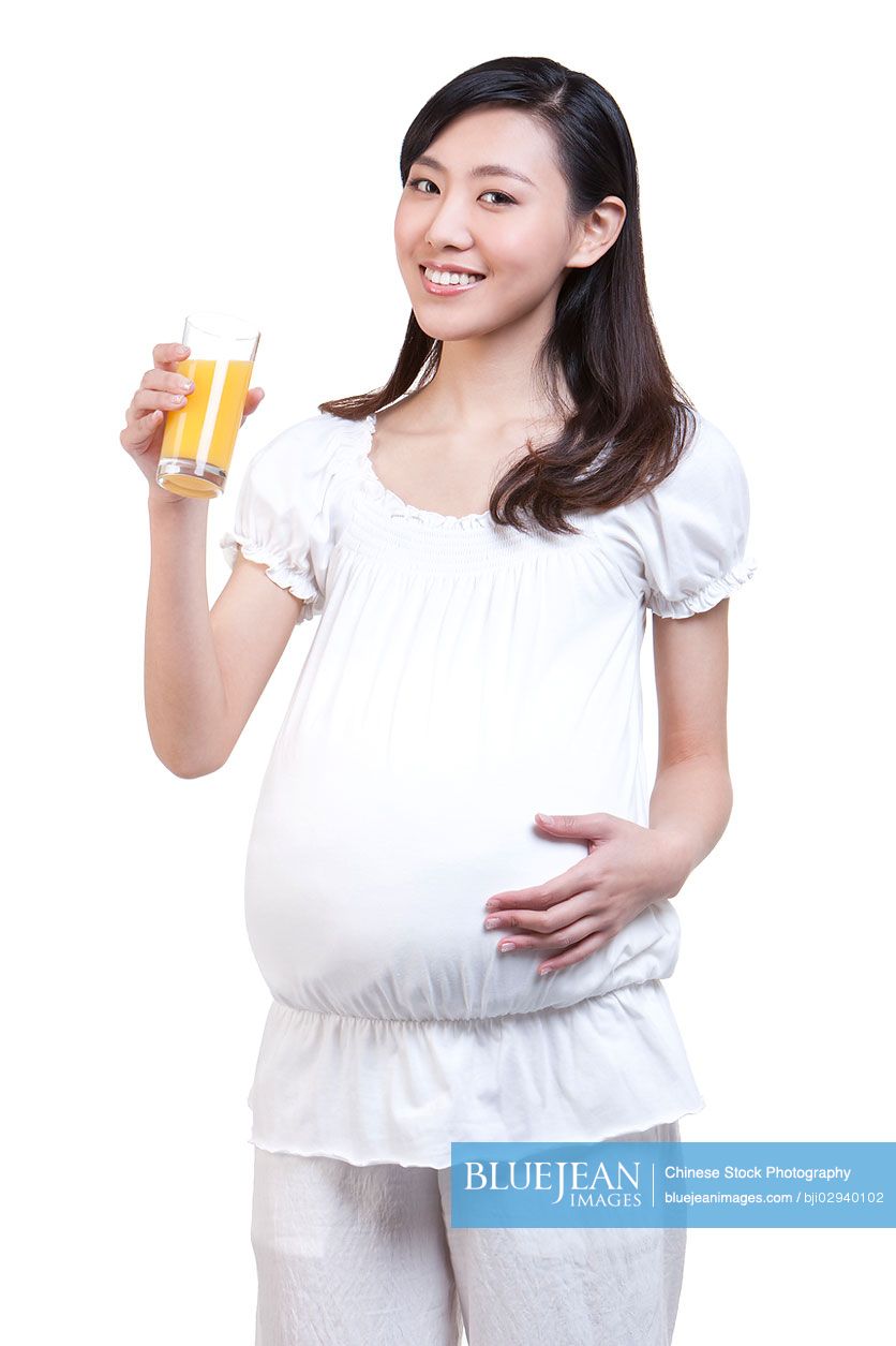 Pregnant Chinese woman with orange juice-High-res stock photo for download