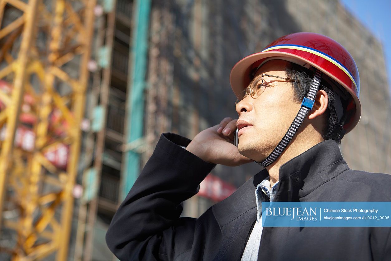 Chinese businessman in construction site wearing hard hat-High-res ...