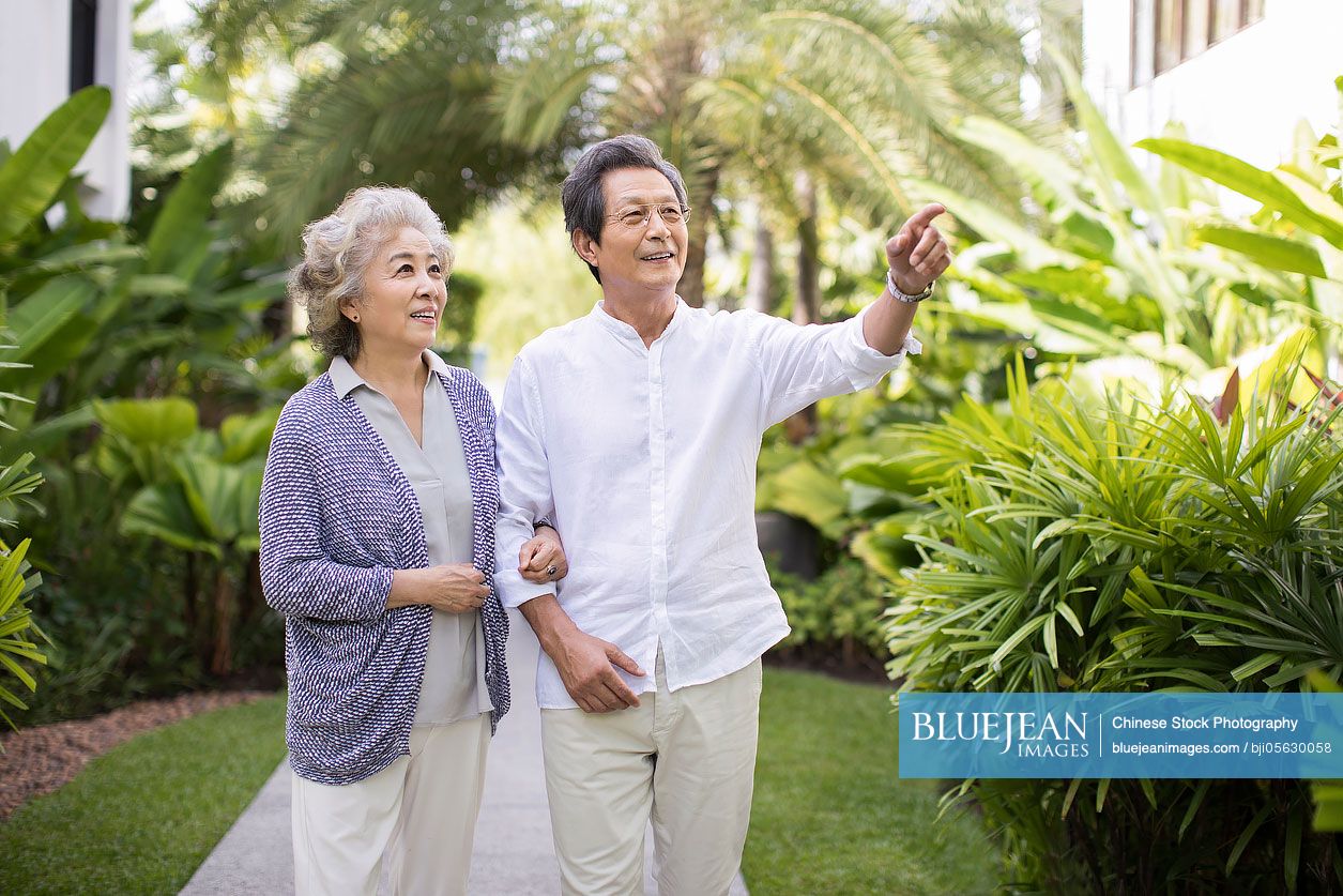 Happy senior Chinese couple enjoying the view in courtyard-High-res stock photo for download