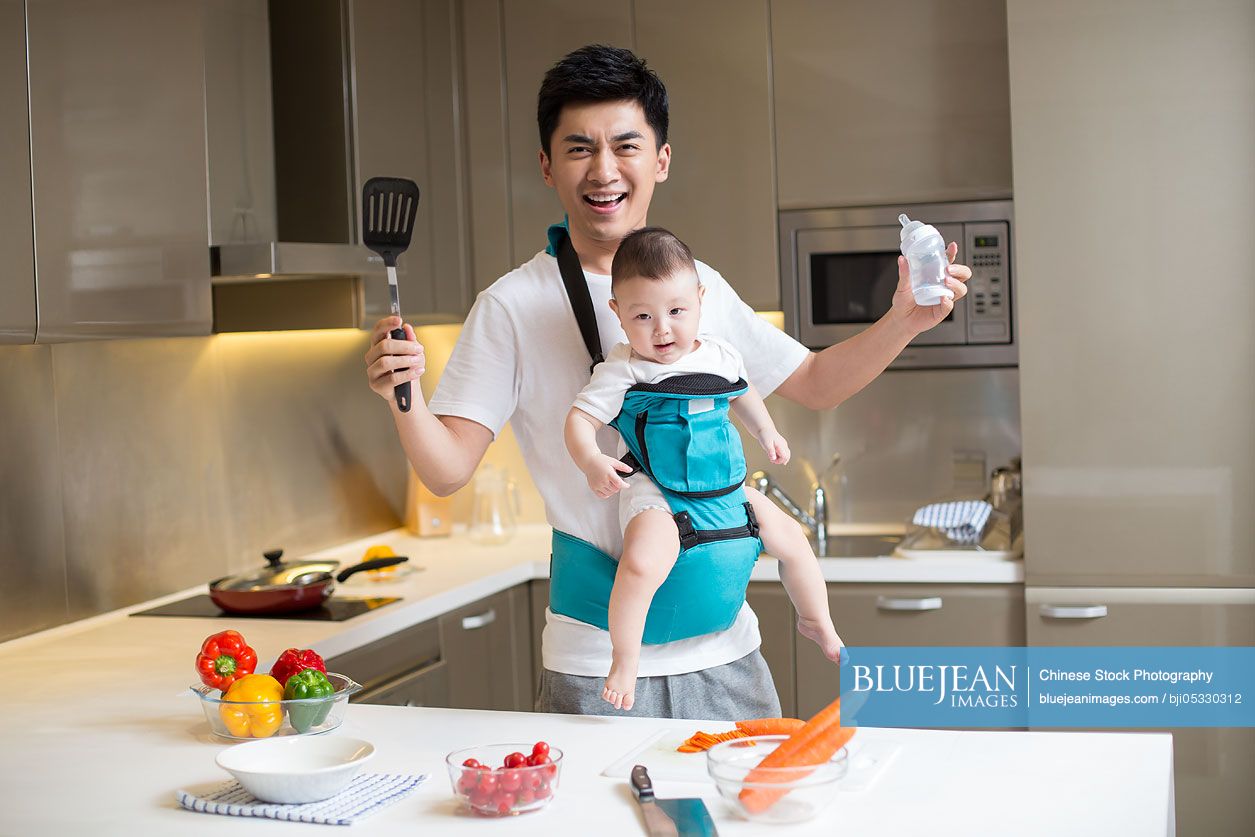 Chinese father holding baby and cooking in the kitchen-High-res stock ...