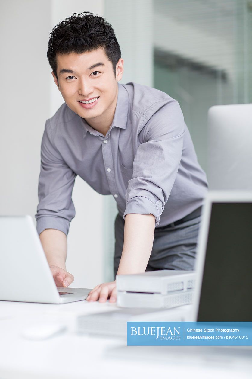 Young Chinese businessman using laptop in office-High-res stock photo ...
